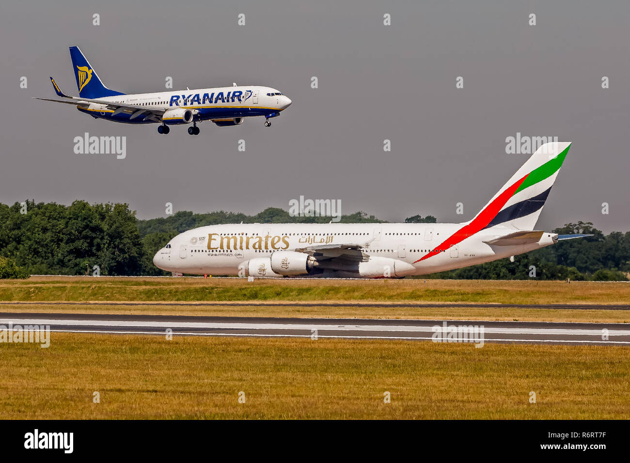 An Emirates Airline Airbus A380 taxying for take off, whilst a Ryanair ...