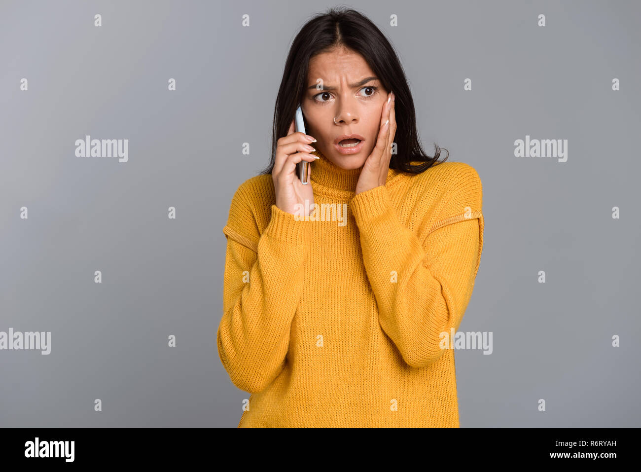 Image of a sad scared woman posing isolated over grey wall background ...