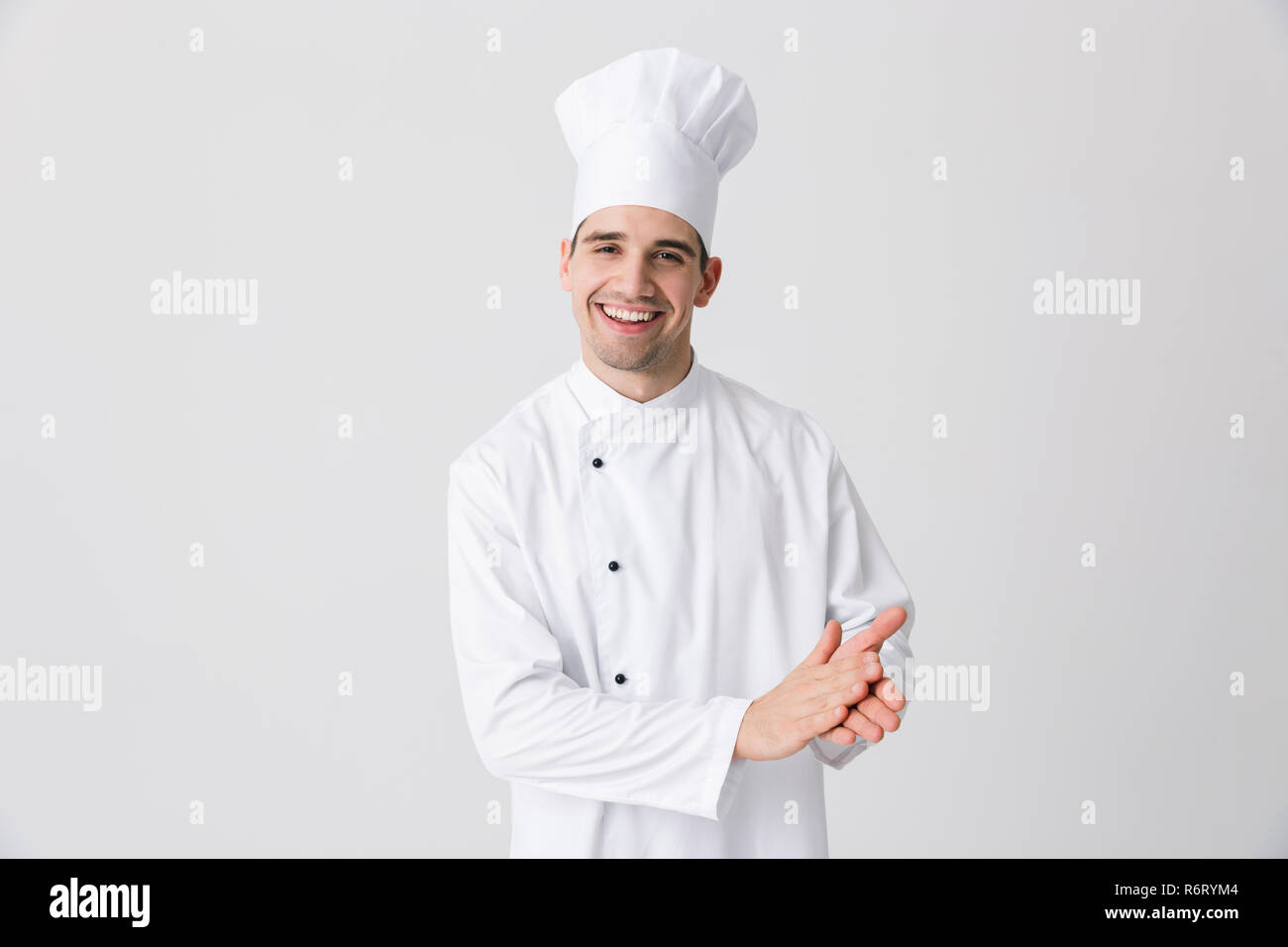 Photo of handsome young man chef indoors isolated over white wall ...