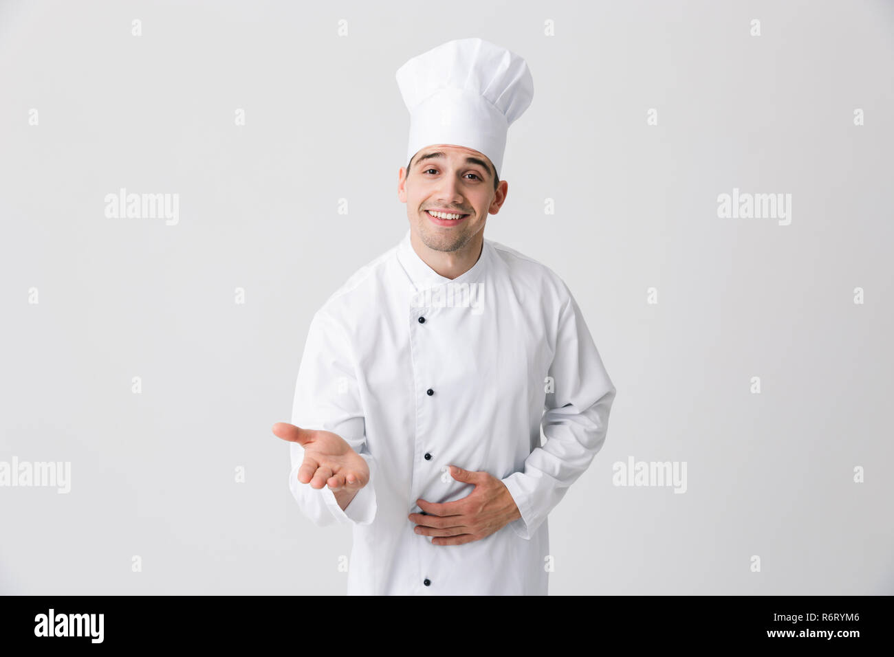 Photo of handsome young man chef indoors isolated over white wall ...