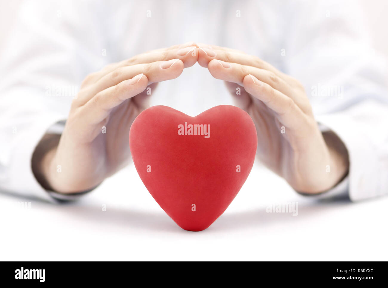 Red heart covered by hands. Health insurance or love concept Stock ...