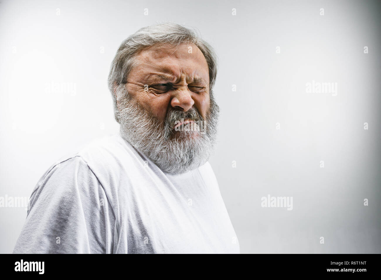 Senior man with disgusted expression repulsing something on white Stock ...