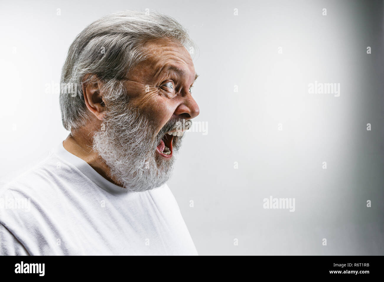 The senior emotional angry man screaming on white studio background ...