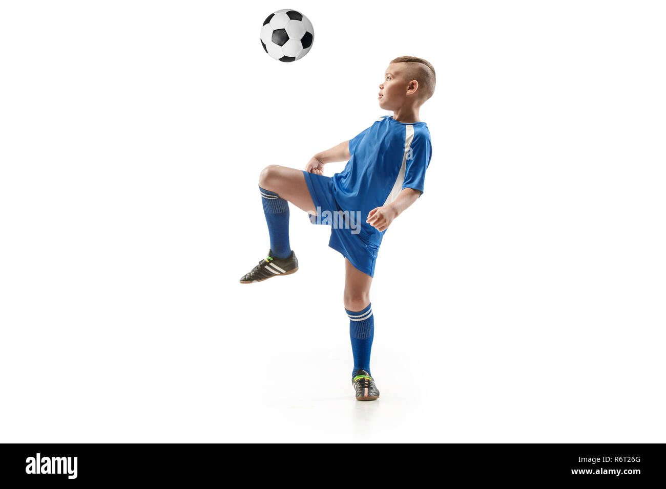 Young boy with soccer ball doing flying kick, isolated on white ...