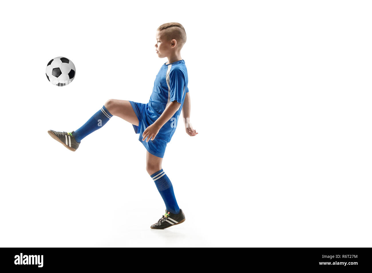 Young boy with soccer ball doing flying kick, isolated on white ...