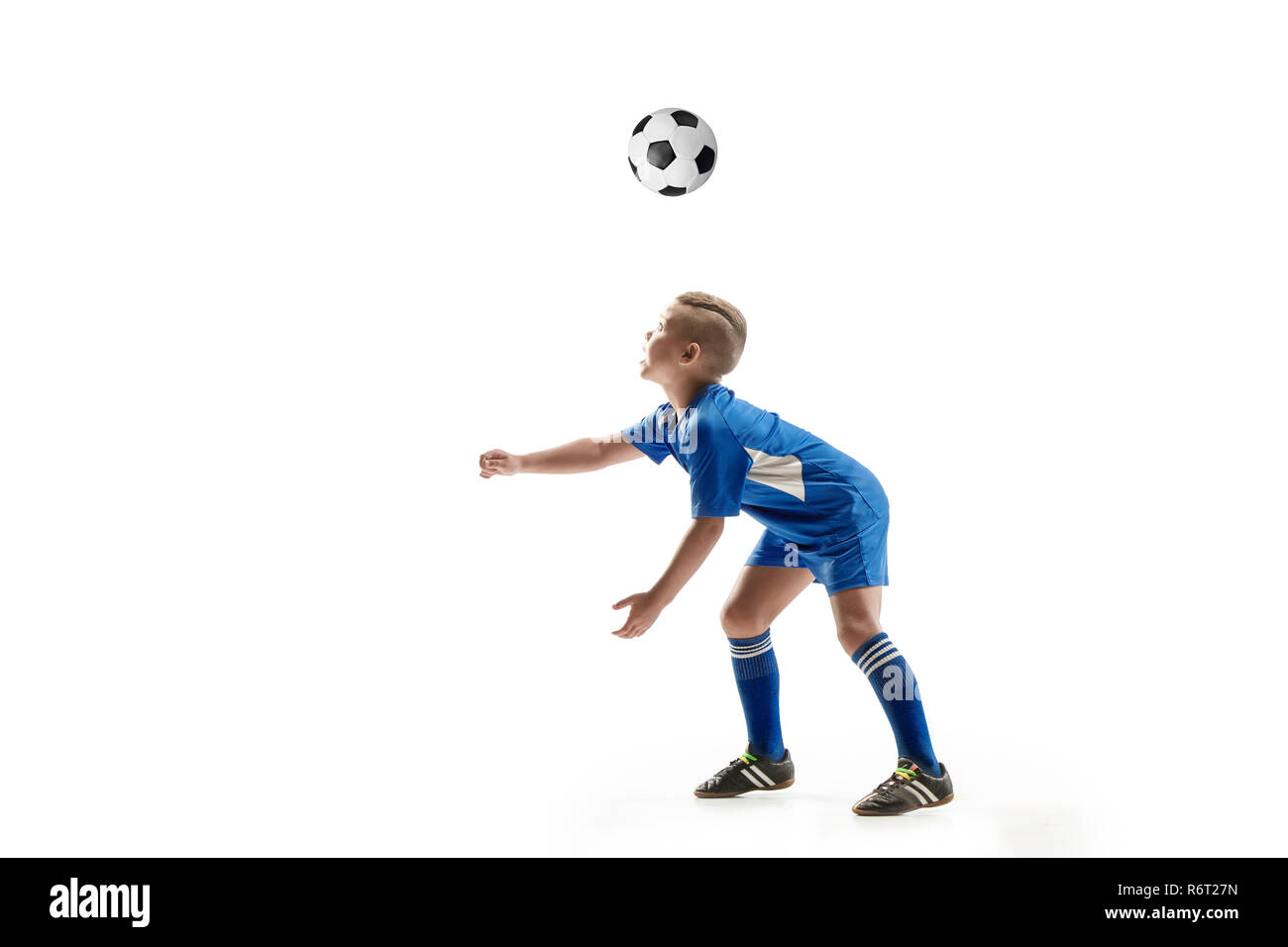Young boy with soccer ball doing flying kick, isolated on white ...