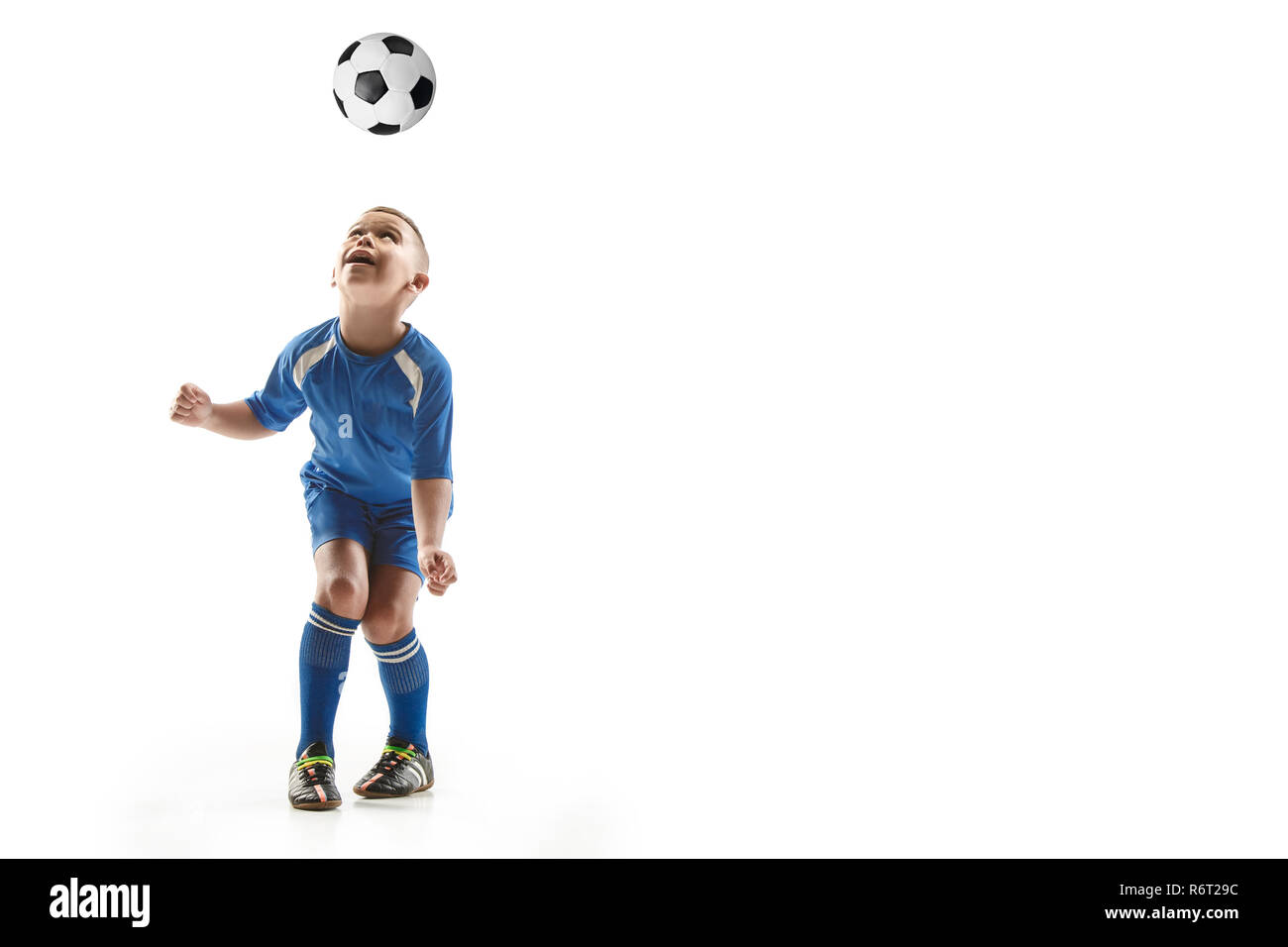 Young boy with soccer ball doing flying kick, isolated on white ...