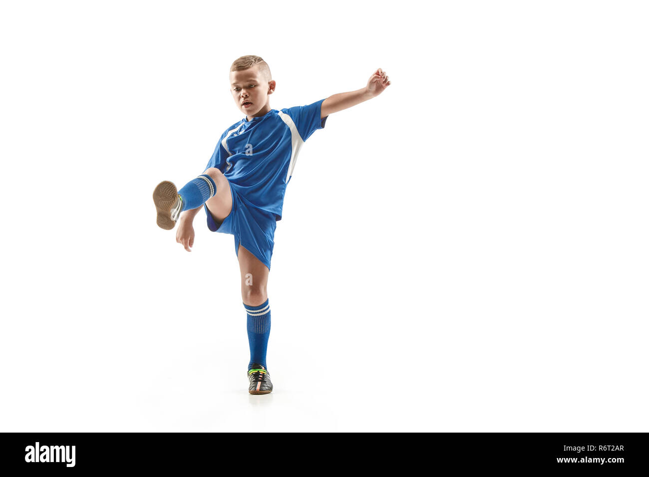 Young boy with soccer ball doing flying kick, isolated on white ...