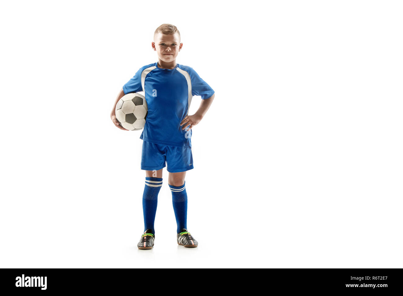 Young fit boy with soccer ball standing isolated on white. The football ...