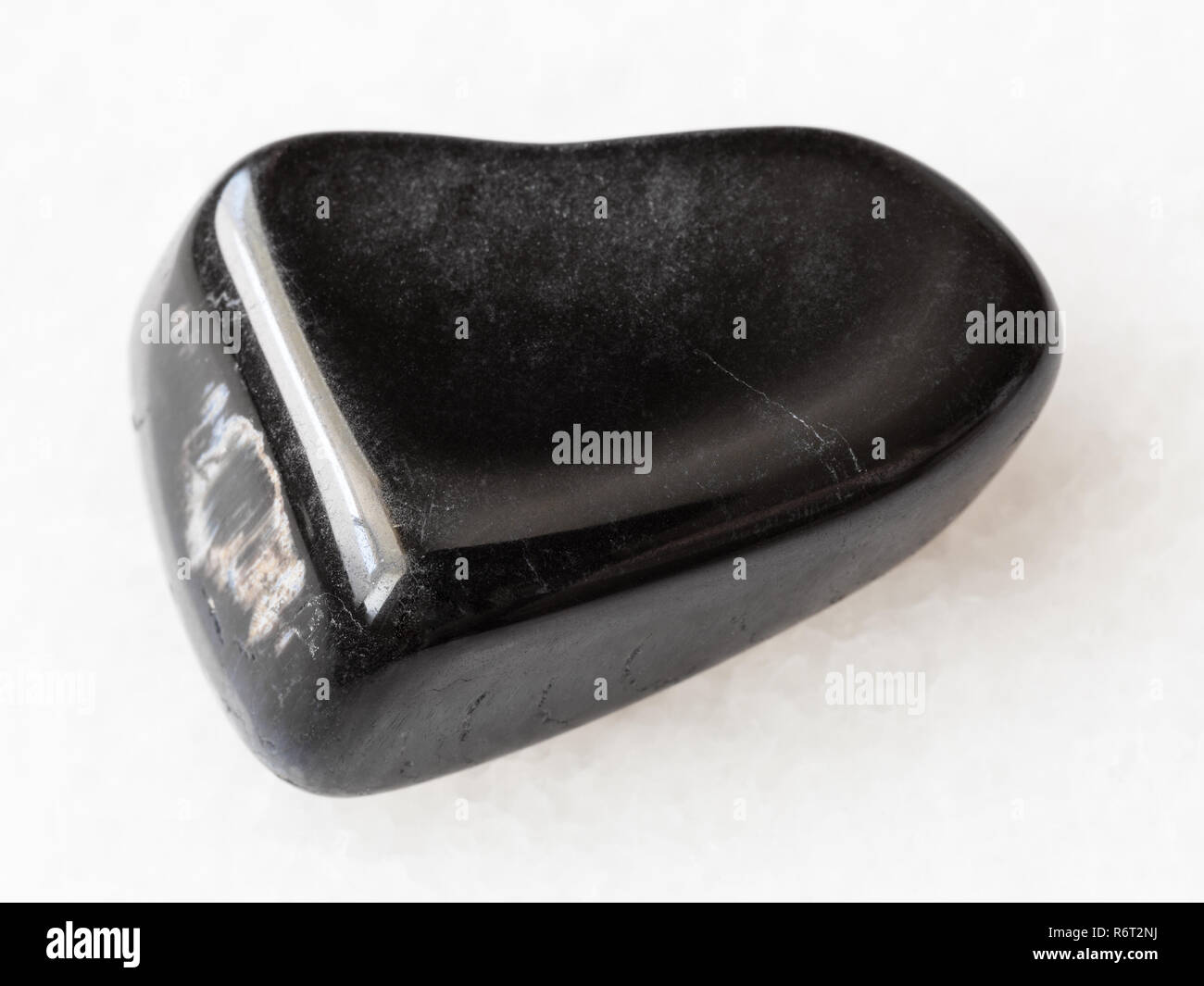 tumbled hawk-eye gemstone on white Stock Photo - Alamy