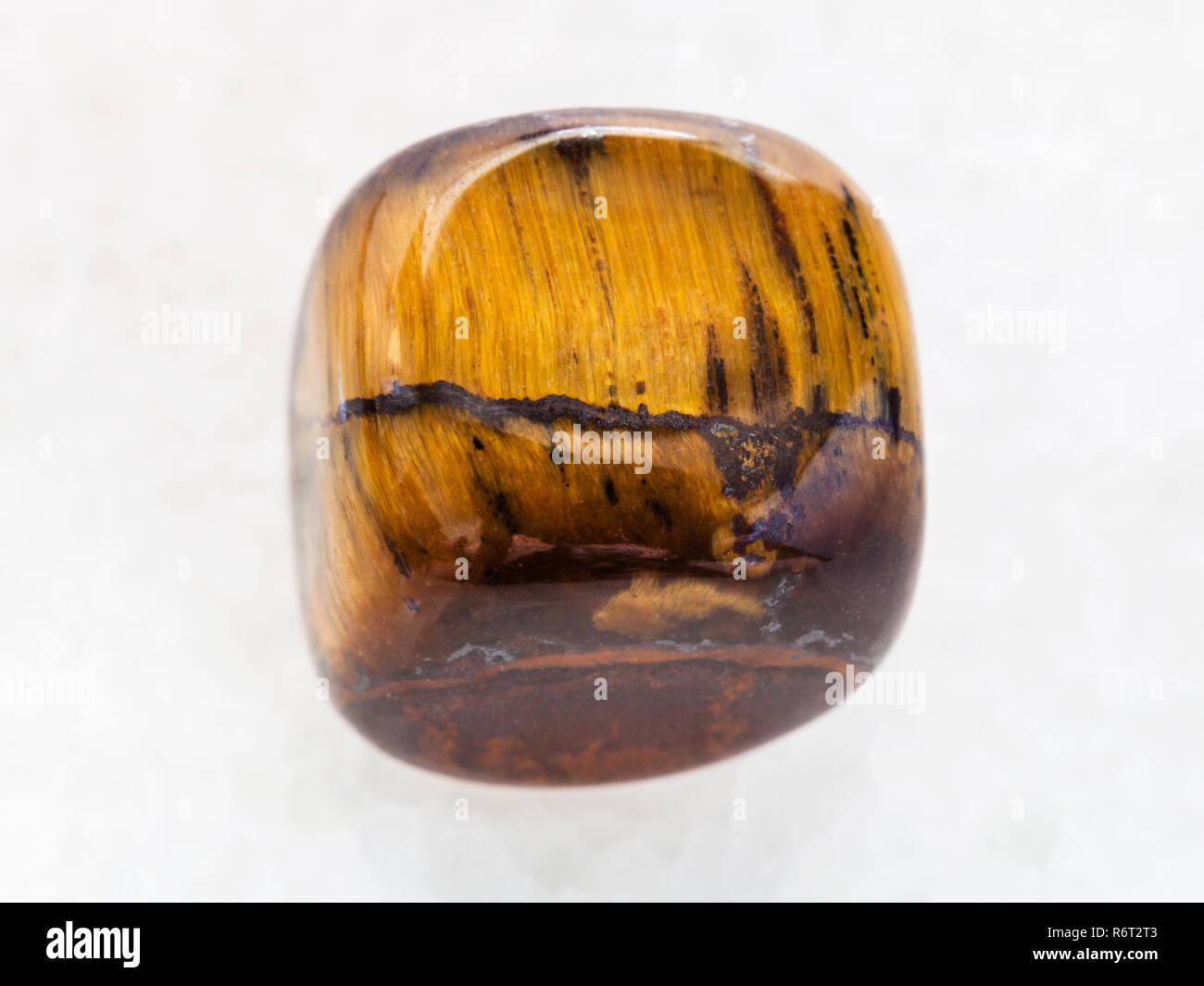 tumbled tiger-eye gem stone on white marble Stock Photo - Alamy