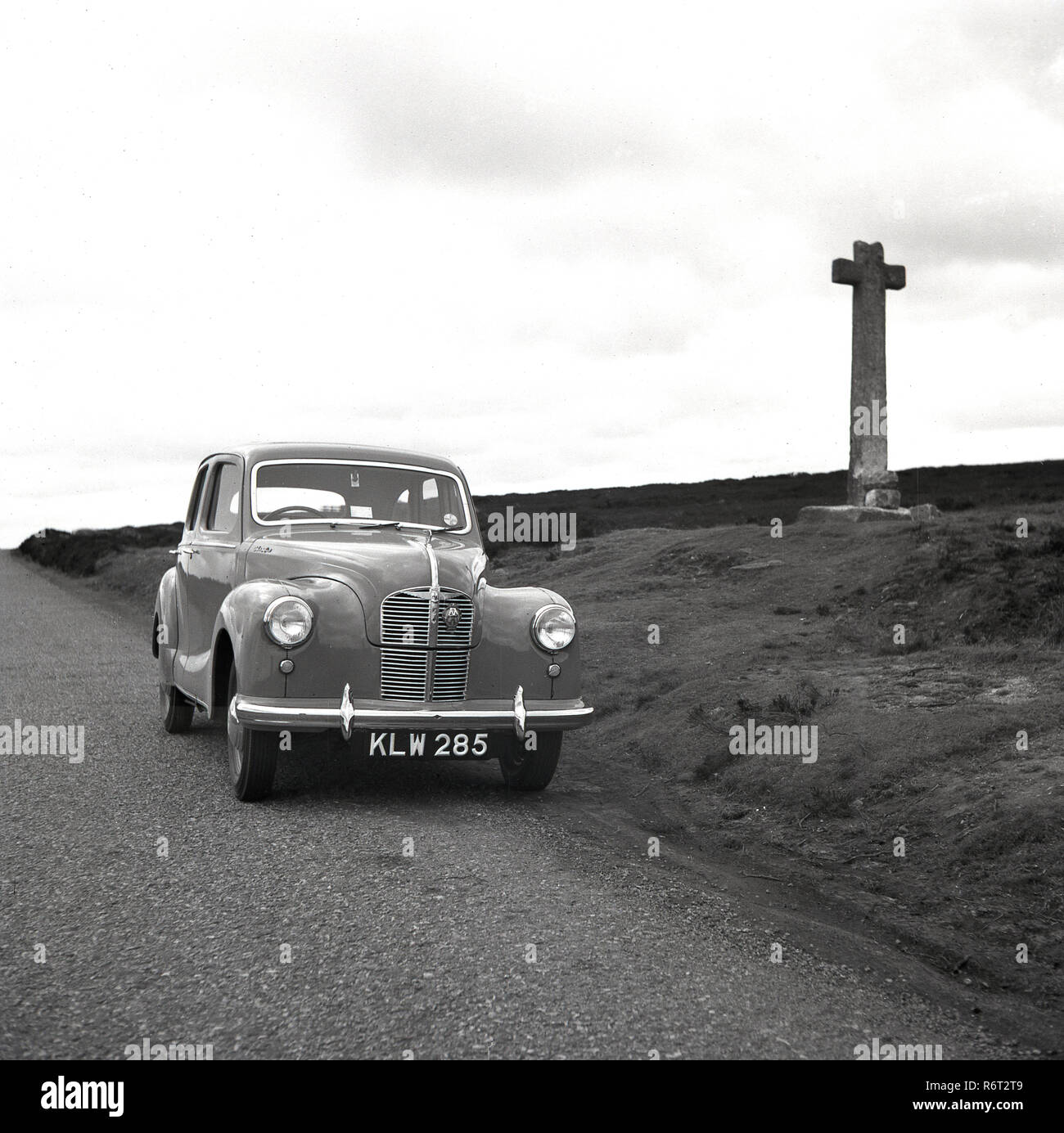 1950s, historical, a motorcar of the era parked on a road on a hillside ...