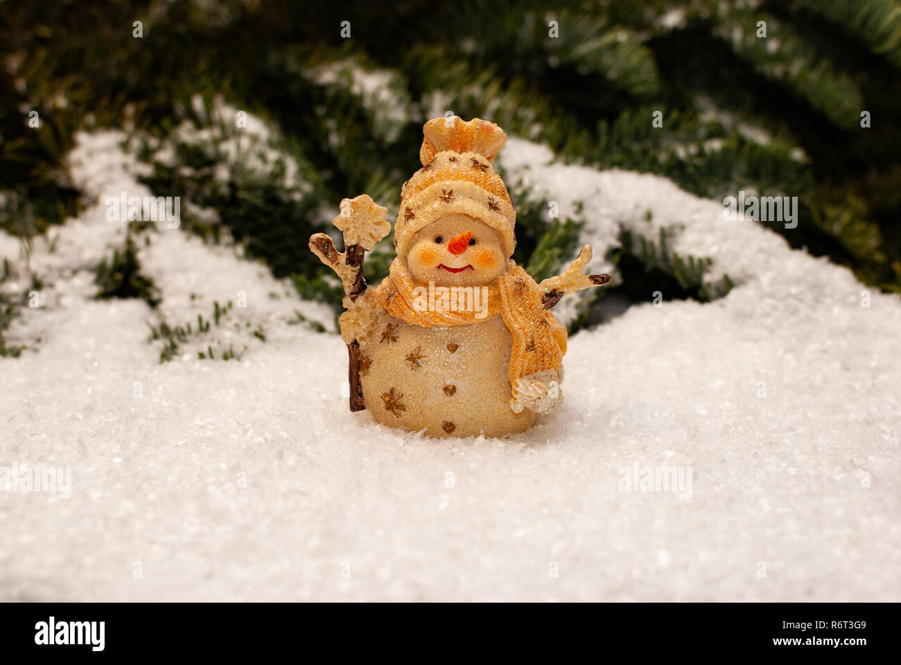 A snowman standing in the snow looking at you, the forest in the back ...
