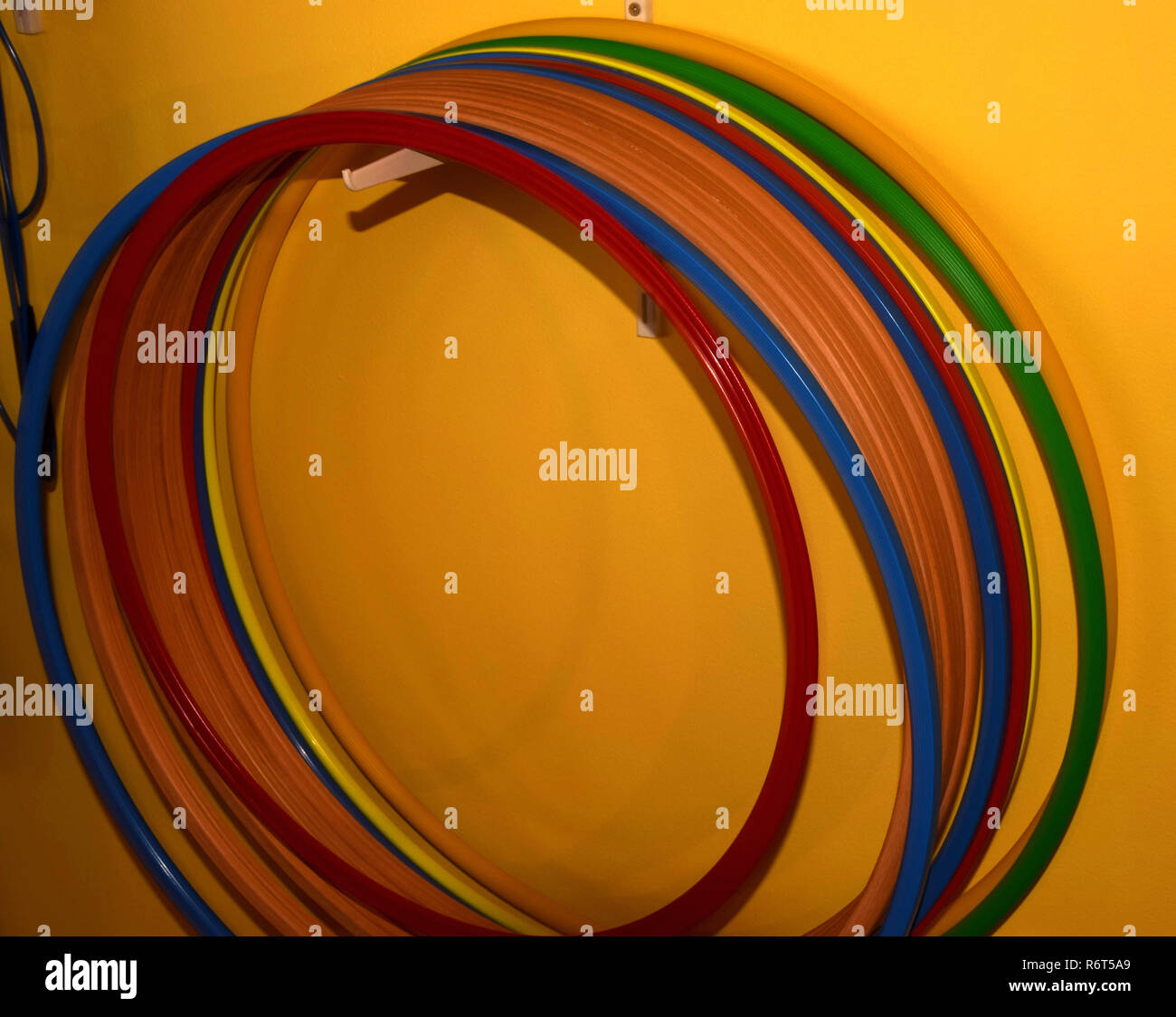 hula hoops made of different materials and colors hanging on a hook in ...