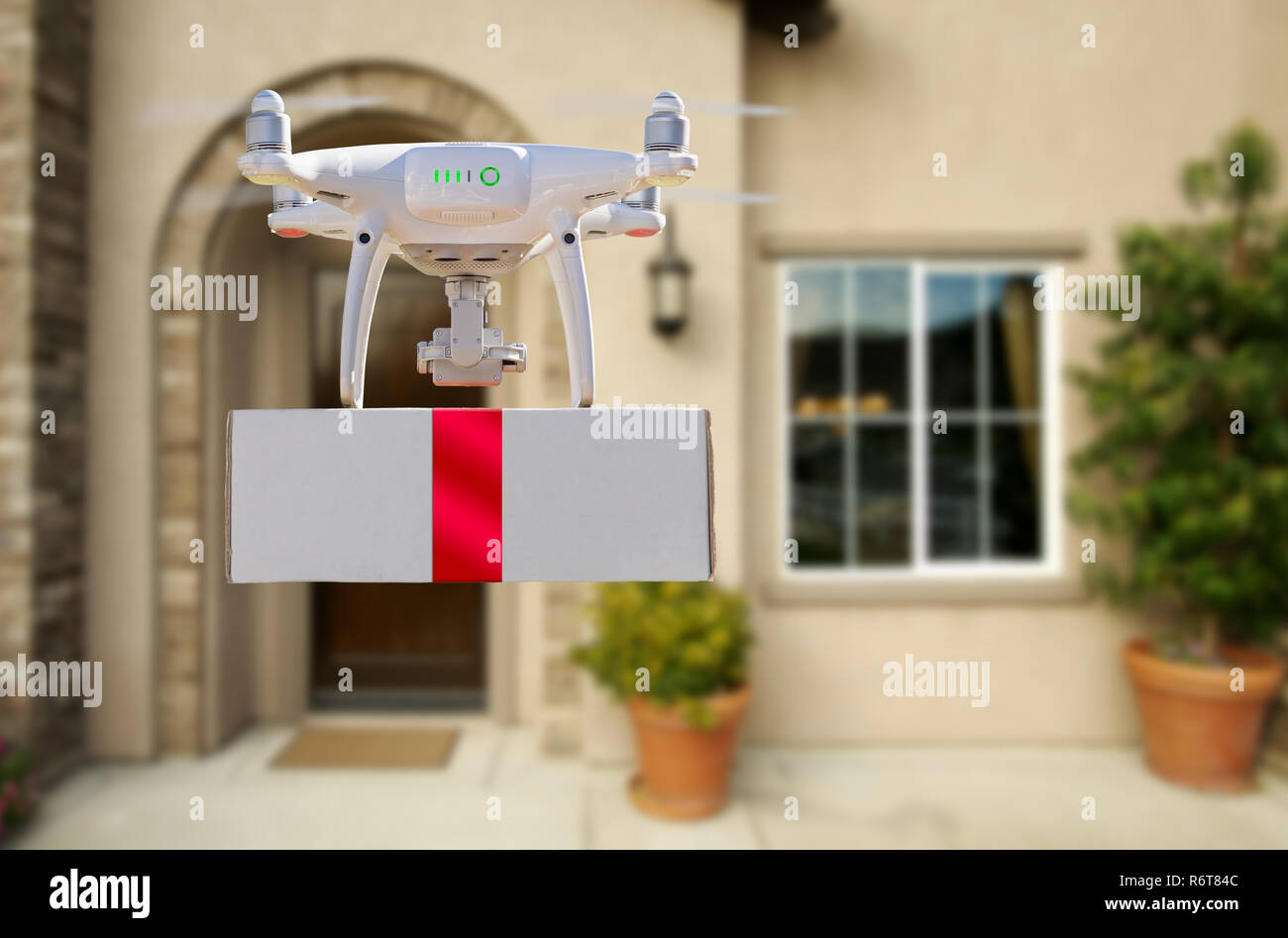 Unmanned Aircraft System (UAV) Quadcopter Drone Delivering Box With Red ...