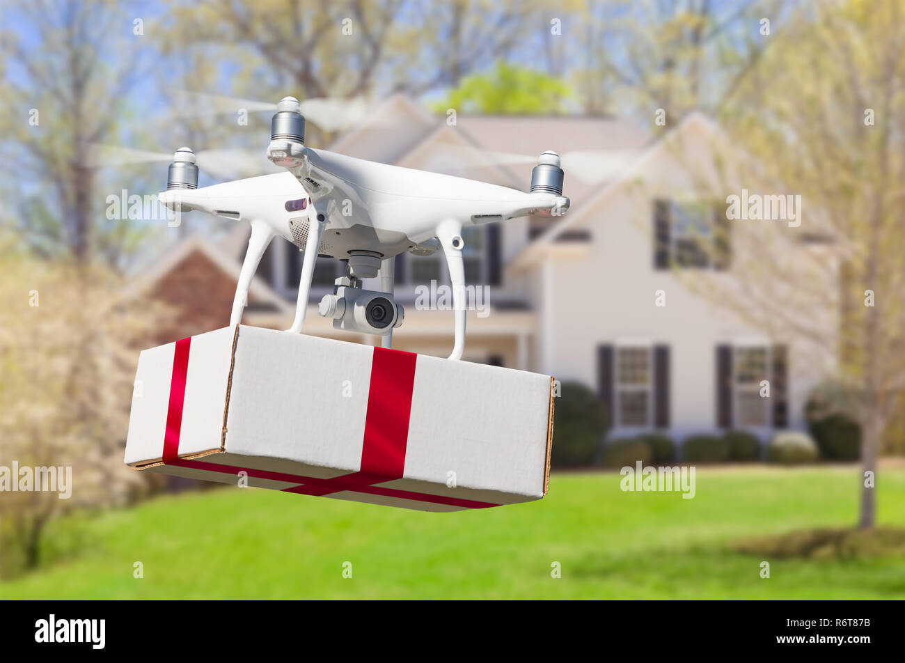 Unmanned Aircraft System (UAV) Quadcopter Drone Delivering Box With Red ...