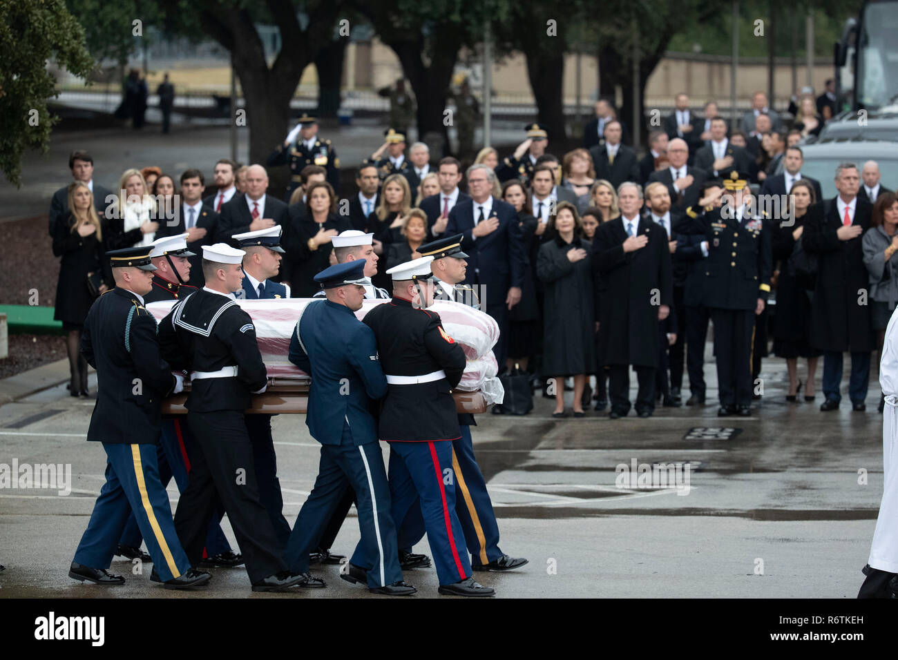 Military honor guard pallbearers carry the casket of former President ...