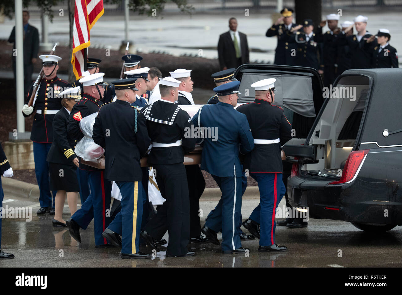 Military honor guard pallbearers carry the casket of former President ...