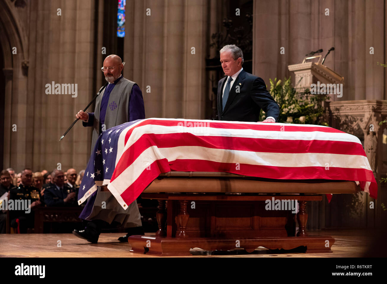 Former President George W. Bush, reaches out to touch the flag draped ...
