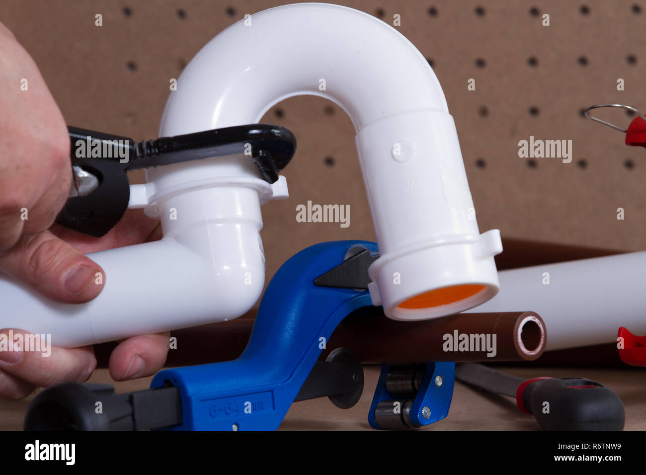 plumber at work on his workbench to fit pipes Stock Photo - Alamy