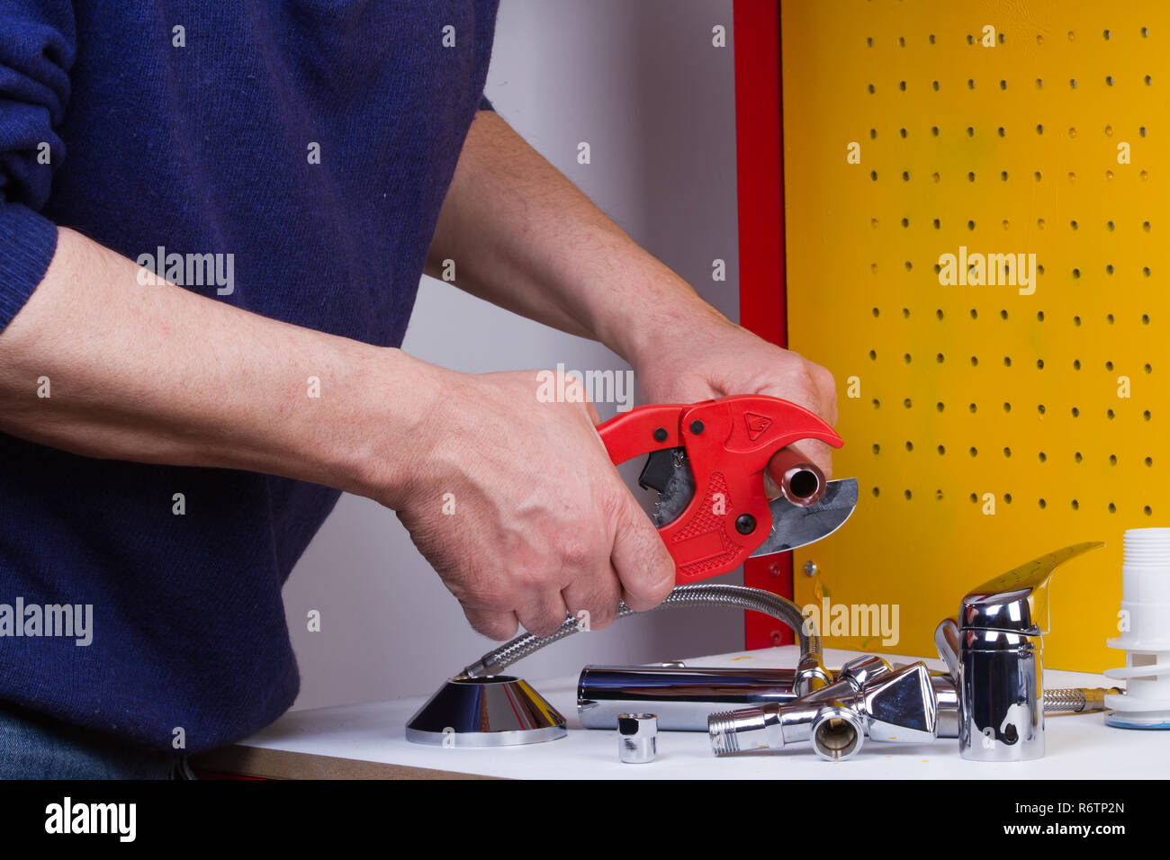 plumber at work on his workbench to fix pipes Stock Photo - Alamy