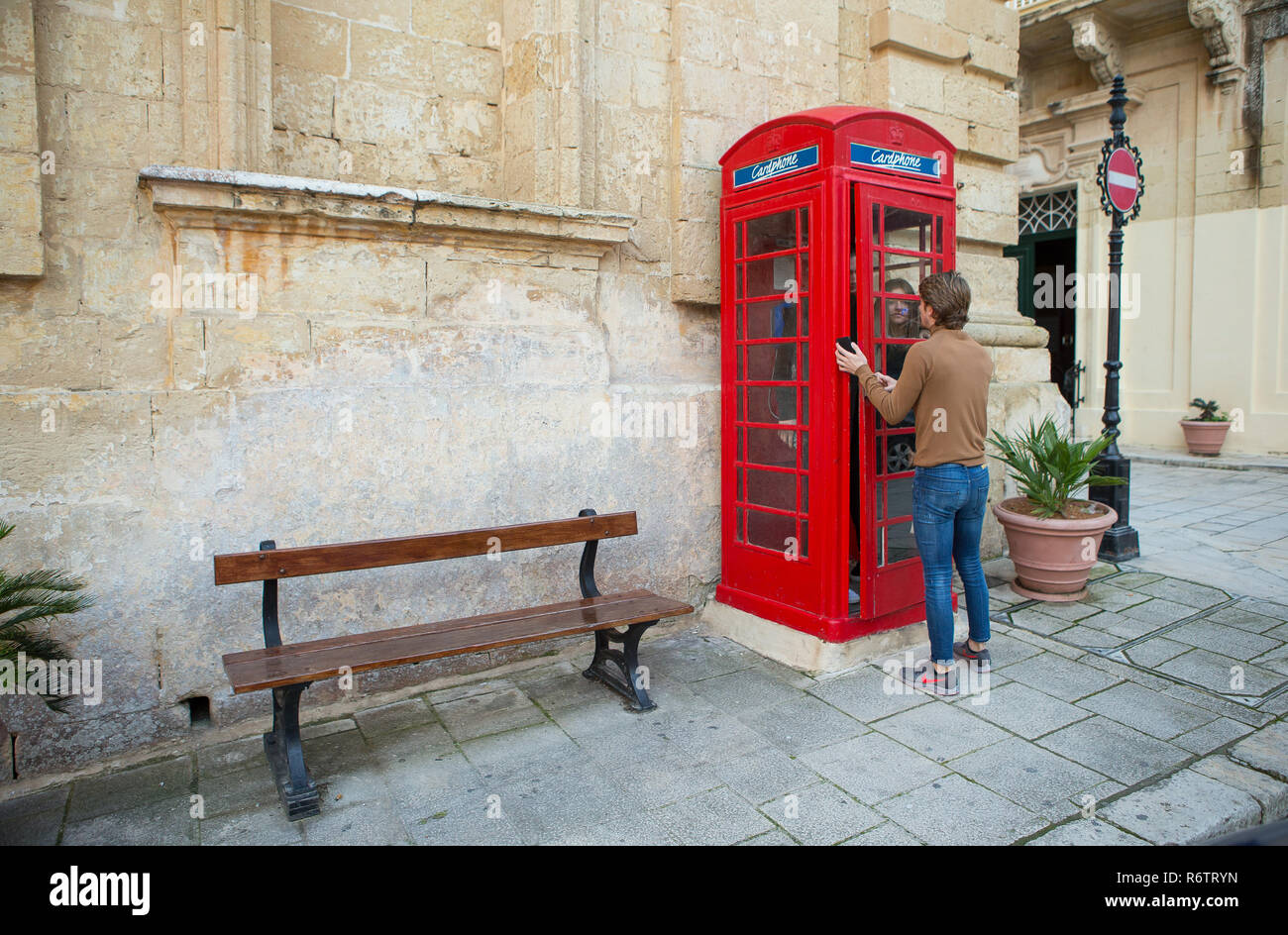 Tourists take photographs in a British red telephone call box stands in ...