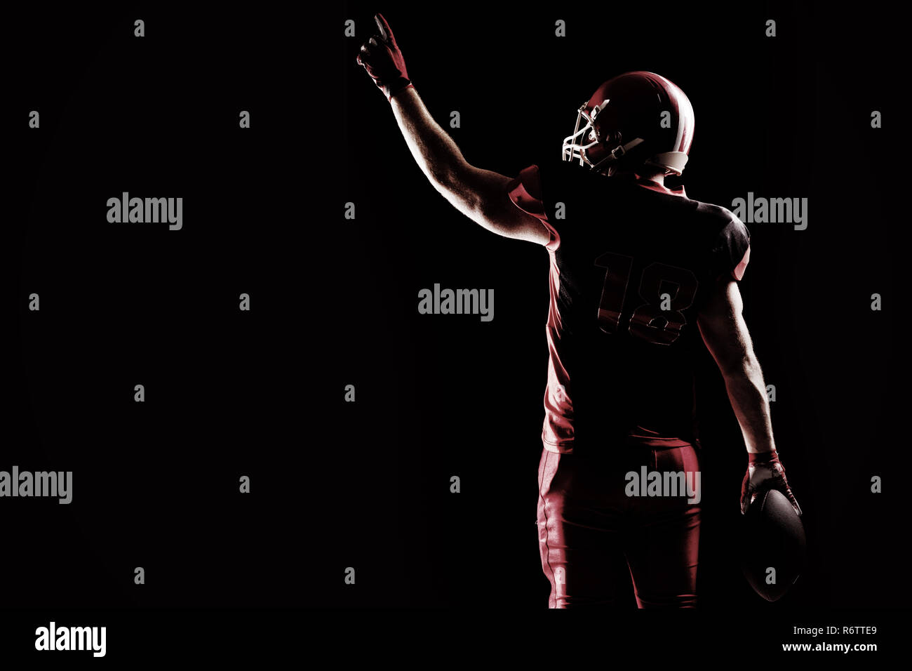 Rear view of American football player in helmet pointing upwards Stock ...