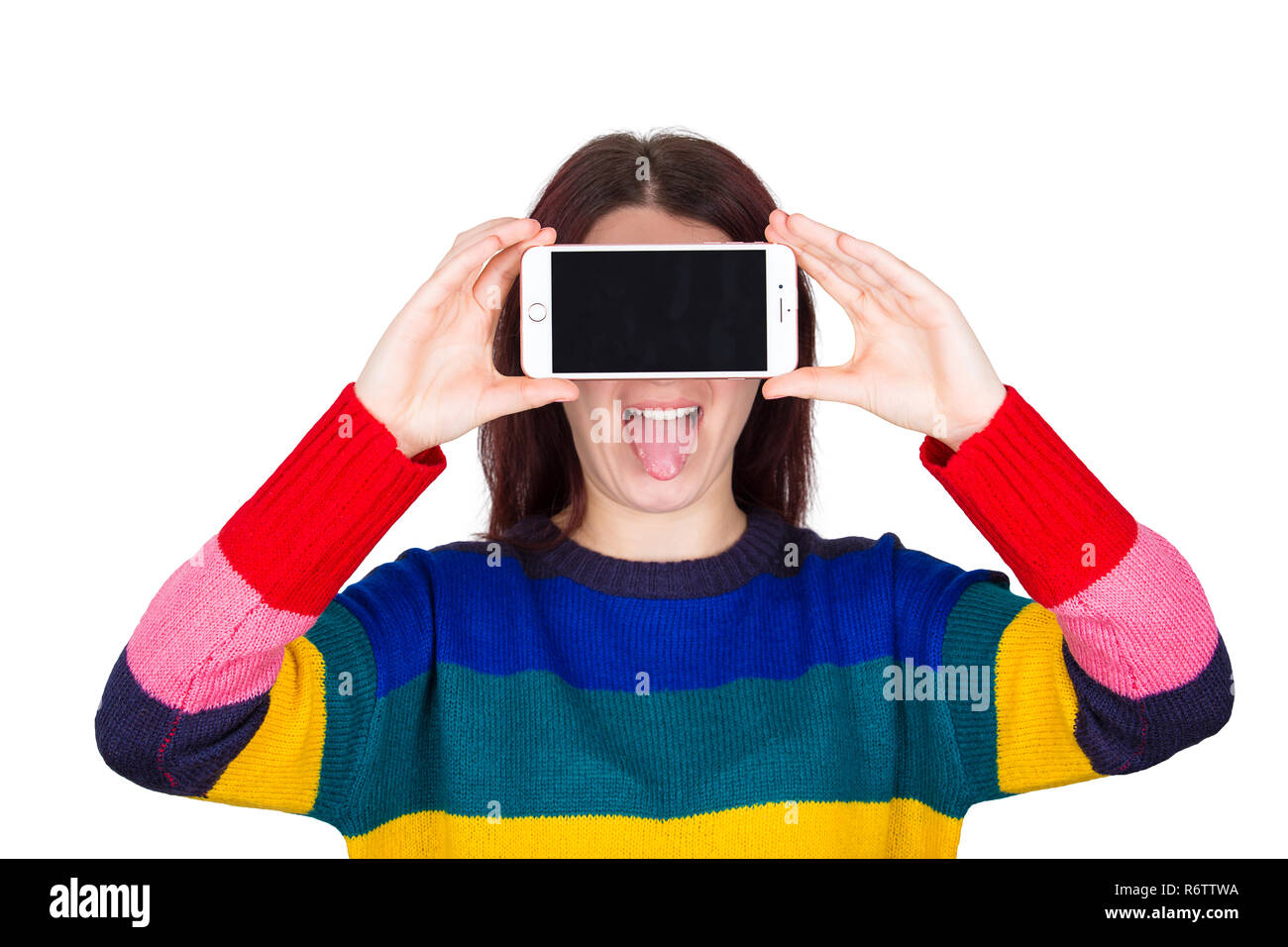 Funny young woman showing tongue while holding mobile phone close to ...