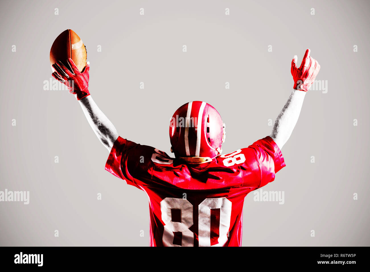 American football player in helmet holding rugby ball with arms in the ...
