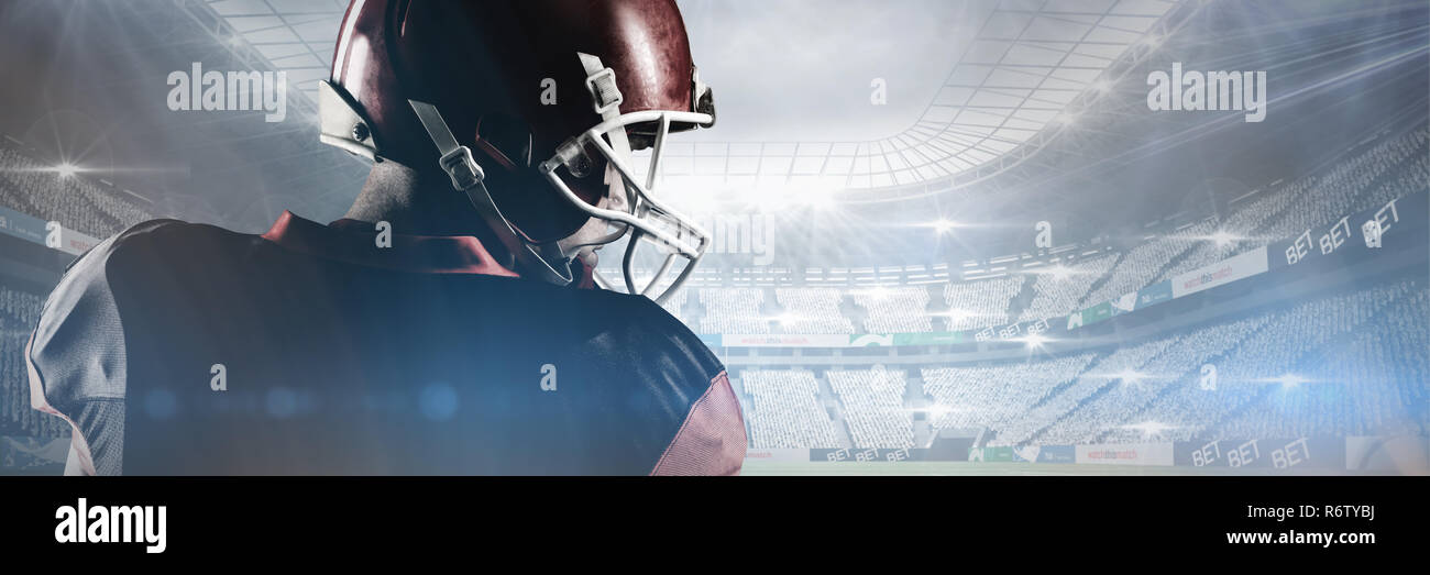 Rear view of American football player in helmet looking off to the side ...