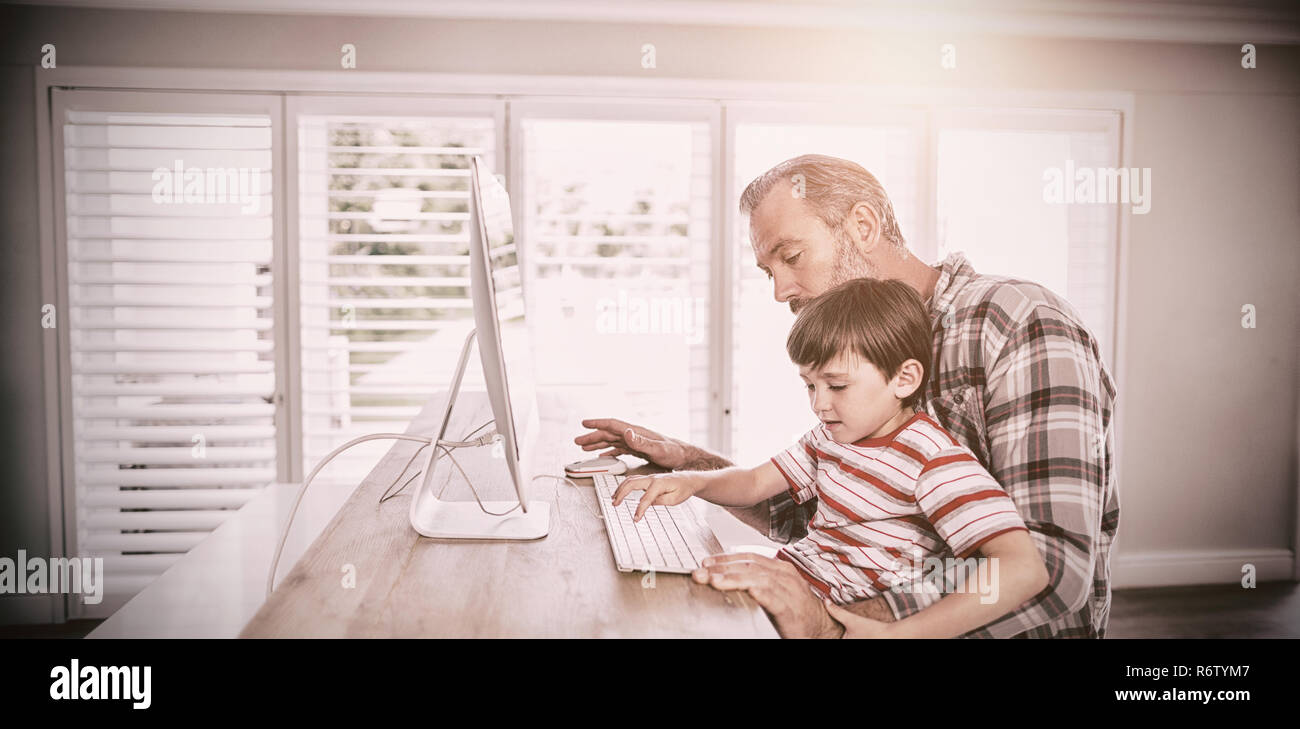 Father and son working on computer at home Stock Photo - Alamy