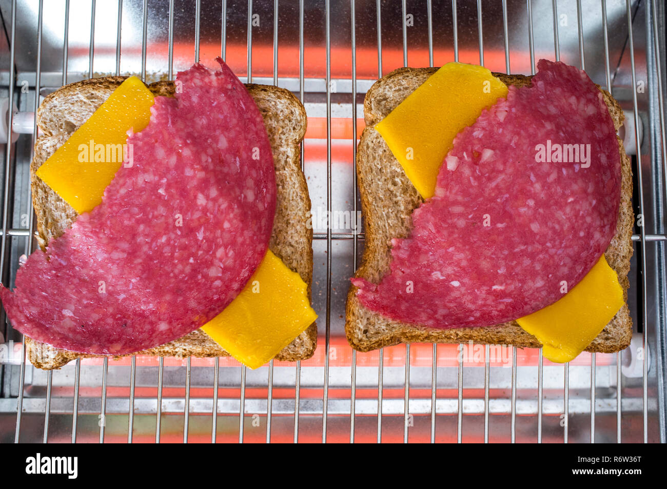 Two toast with salami and melting cheese over flat toaster Stock Photo ...