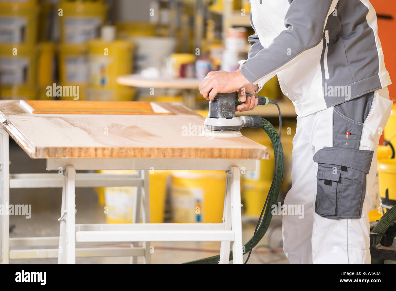 a painter at the wooden door grinding Stock Photo - Alamy