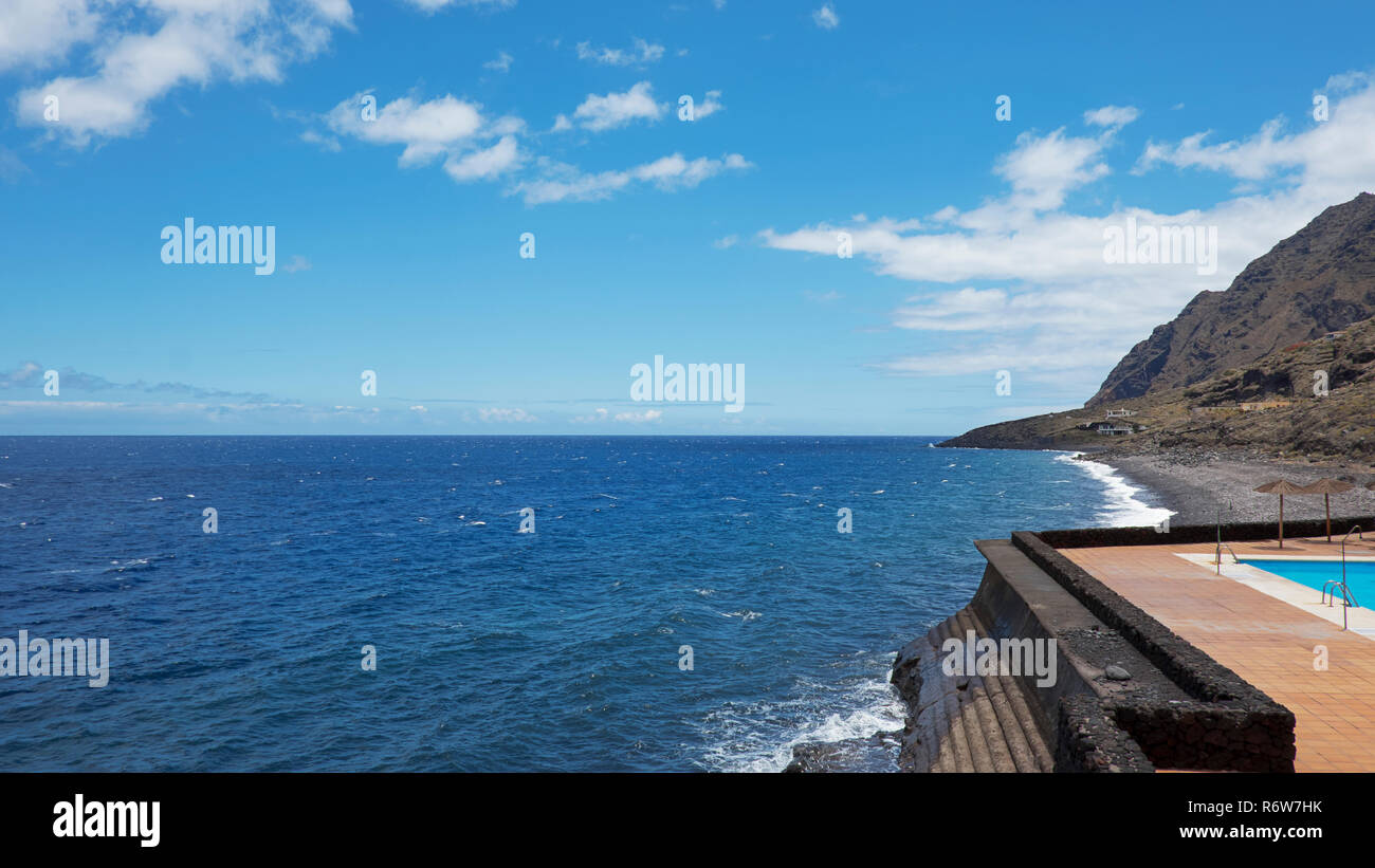 Coastal views with clear ocean, blue sky with scattered clouds and a ...