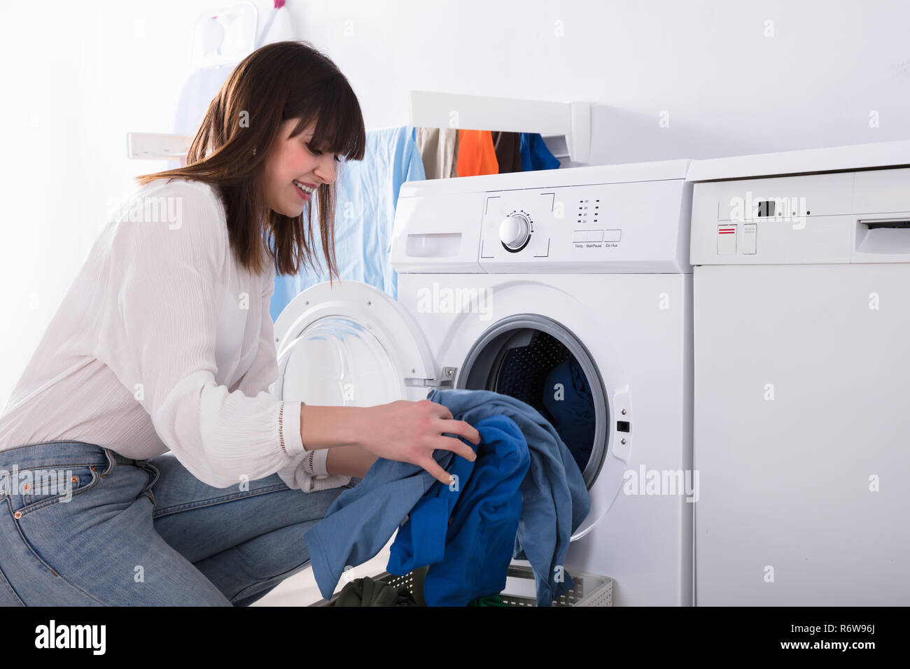 Woman Putting Dirty Cloth Into Washing Machine Stock Photo - Alamy