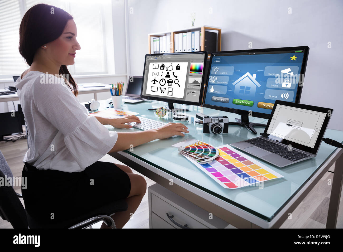 Female Designer Working On Multiple Computer Stock Photo - Alamy