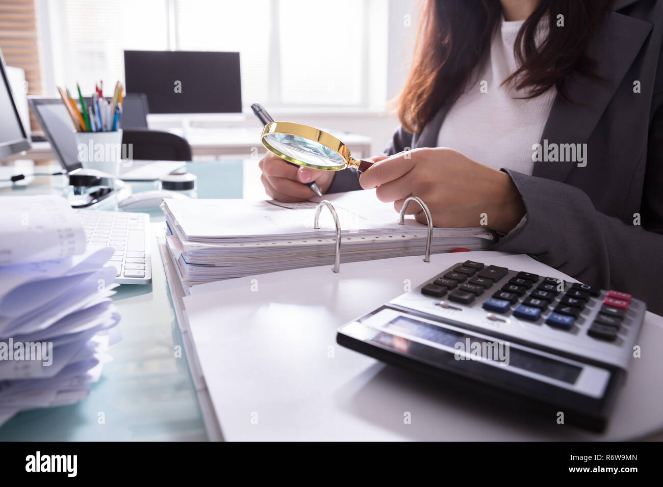 Businesswoman Checking Bill Through Magnifying Glass Stock Photo - Alamy