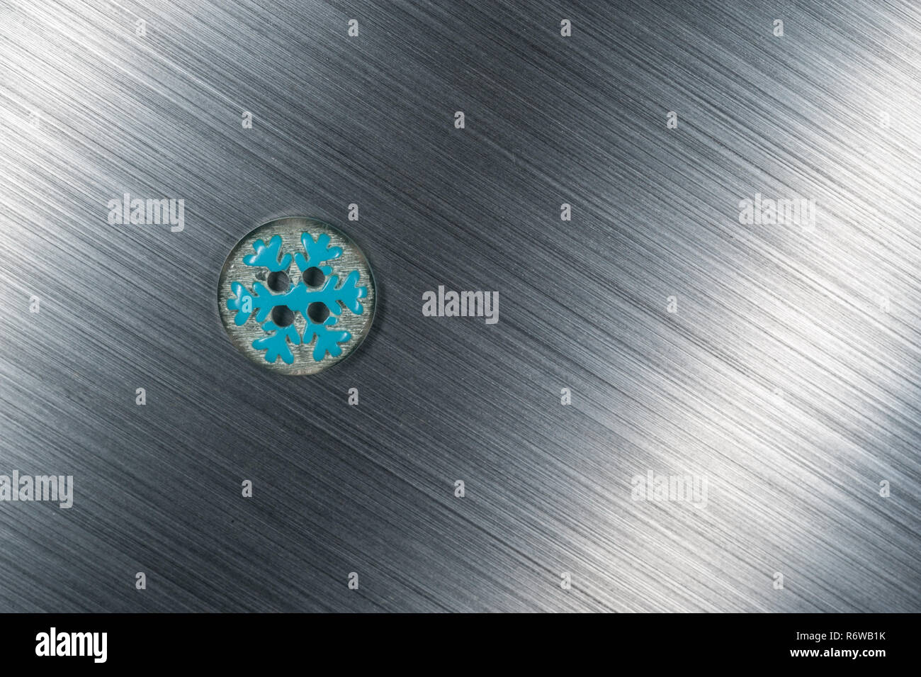 Snow flake sewing button on brushed metal background texture Stock ...