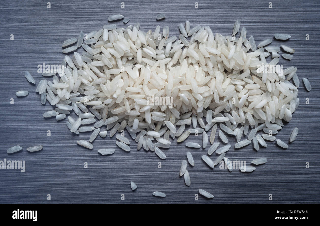 Close-up on uncooked white rice grains on a brushed metal background ...