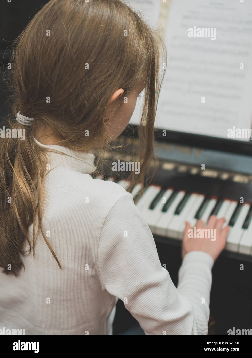 Little girl learning to play the piano Stock Photo - Alamy