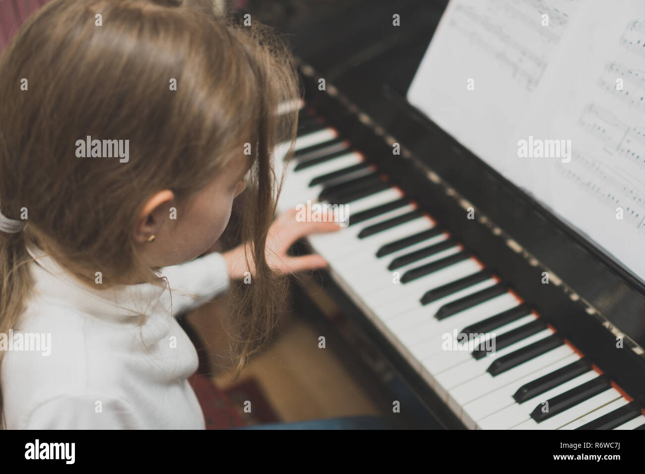 Little girl learning to play the piano Stock Photo - Alamy