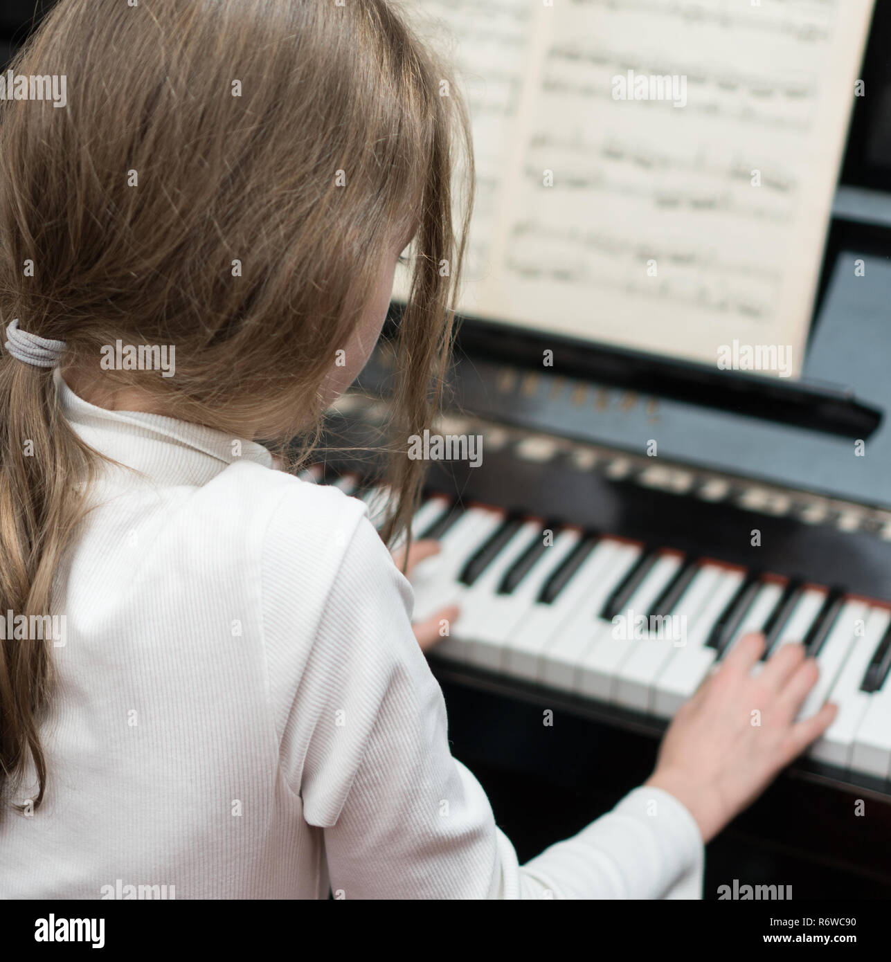 Little girl learning to play the piano Stock Photo - Alamy