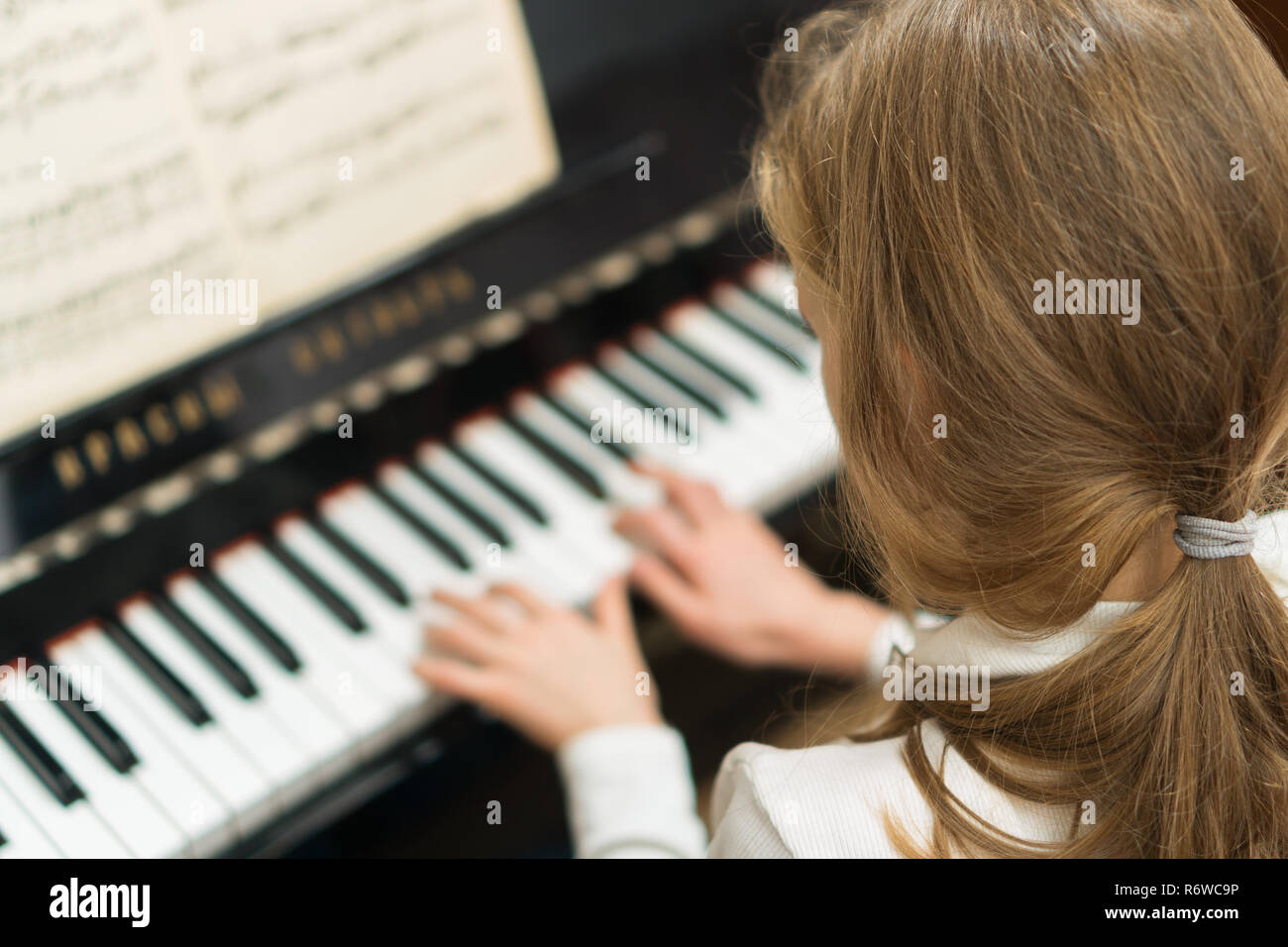Little girl learning to play the piano Stock Photo - Alamy