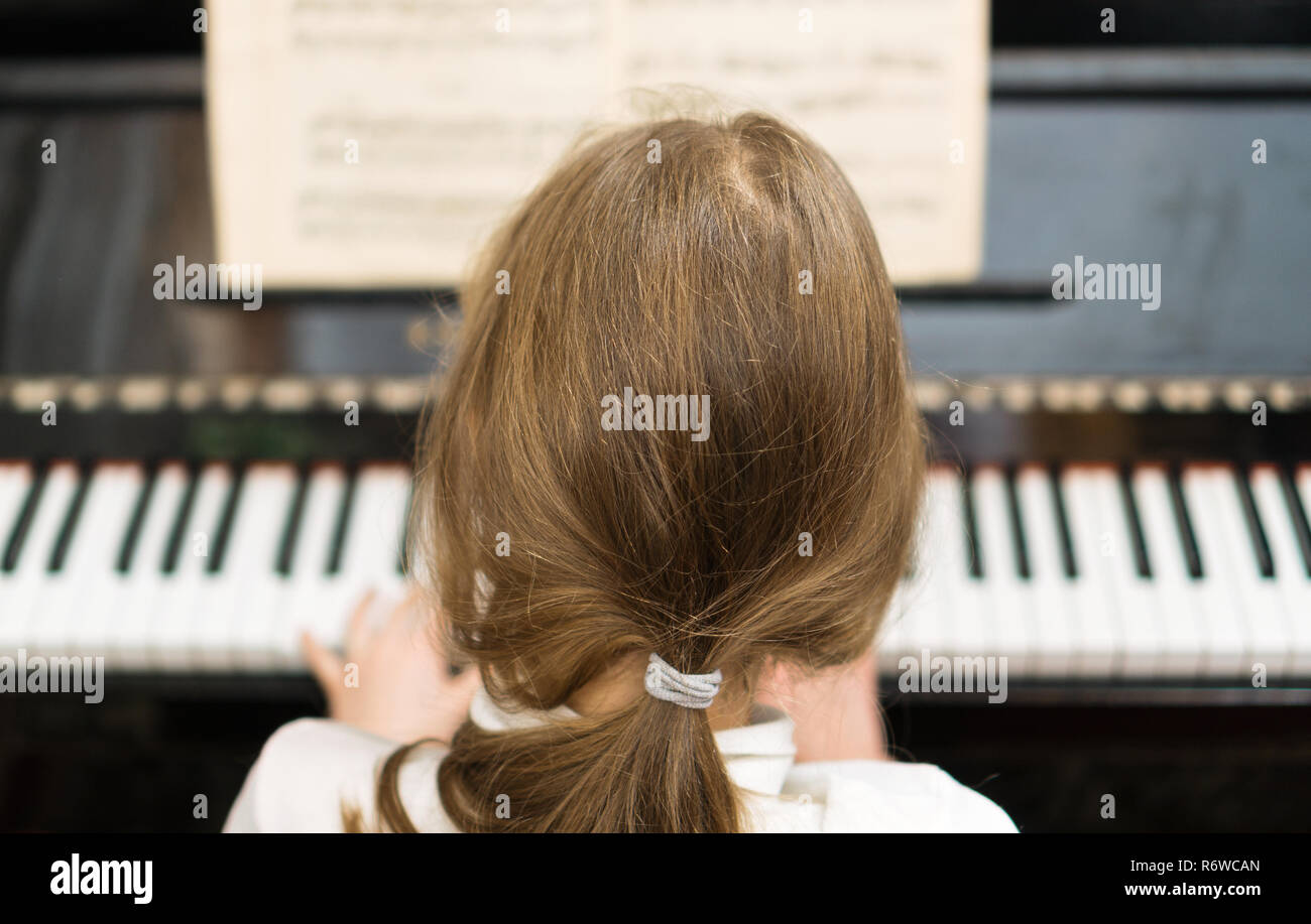 Little girl learning to play the piano Stock Photo - Alamy