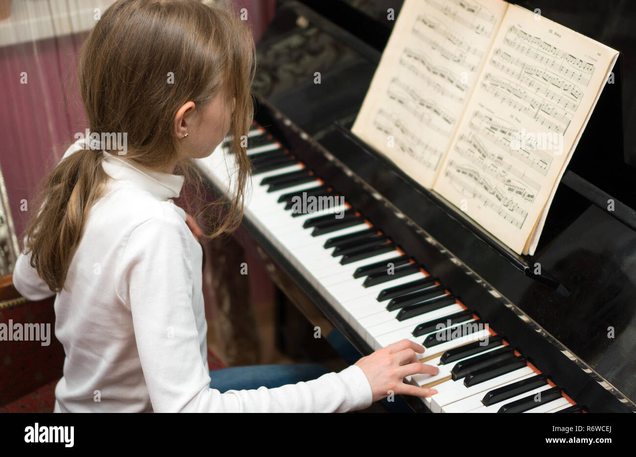 Little girl learning to play the piano Stock Photo - Alamy