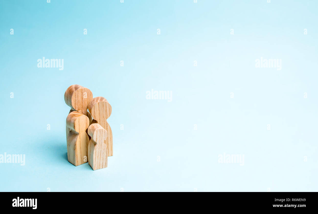 Wooden figurines of the family stand on a blue background. The concept ...