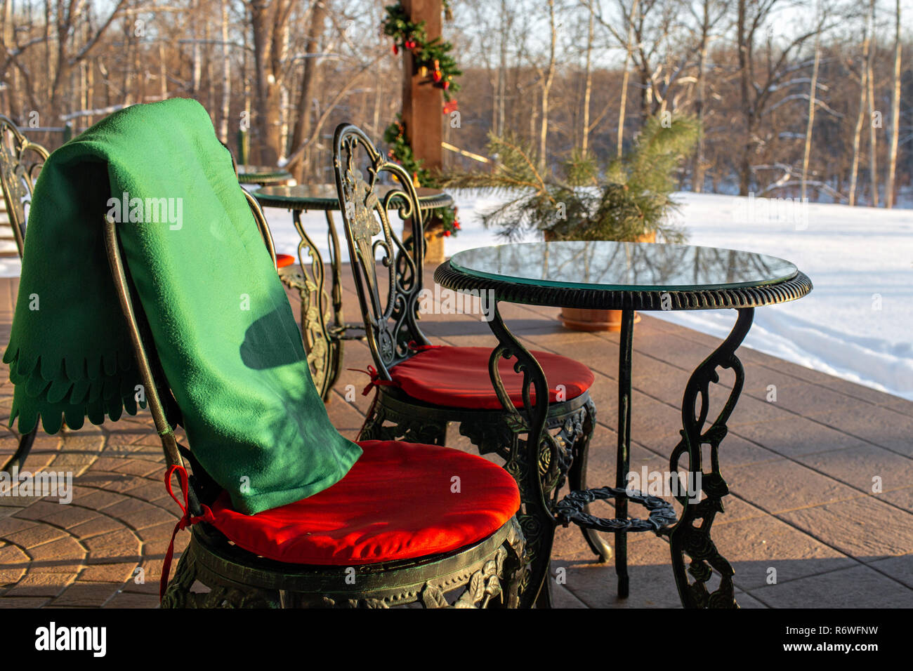 Cast iron chairs and tables with pillows and a blanket on restaurant ...