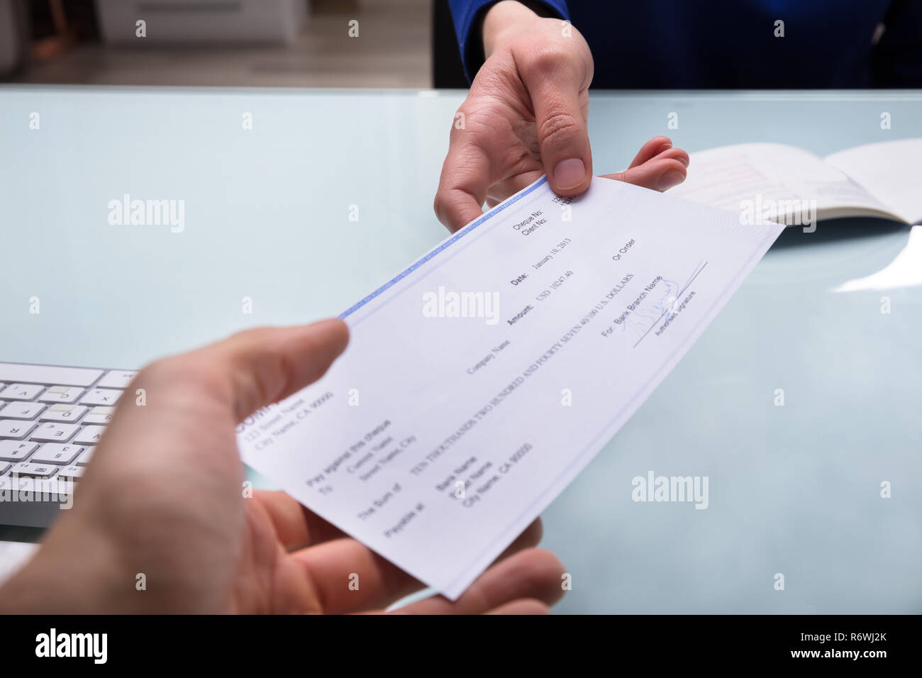 Businessperson Giving Cheque To Colleague Stock Photo - Alamy