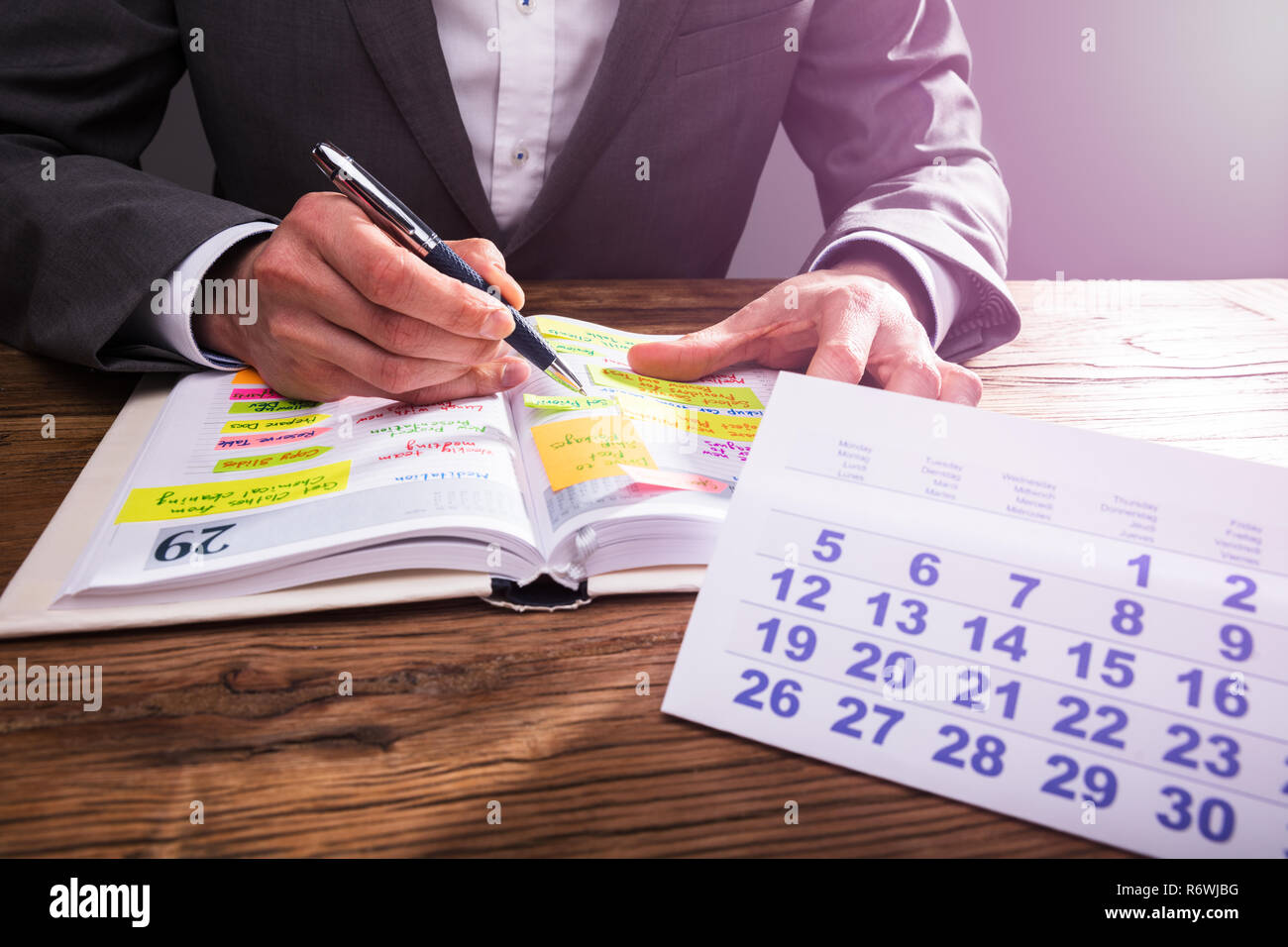 Businessperson's Hand Checking Schedule In Diary Stock Photo - Alamy
