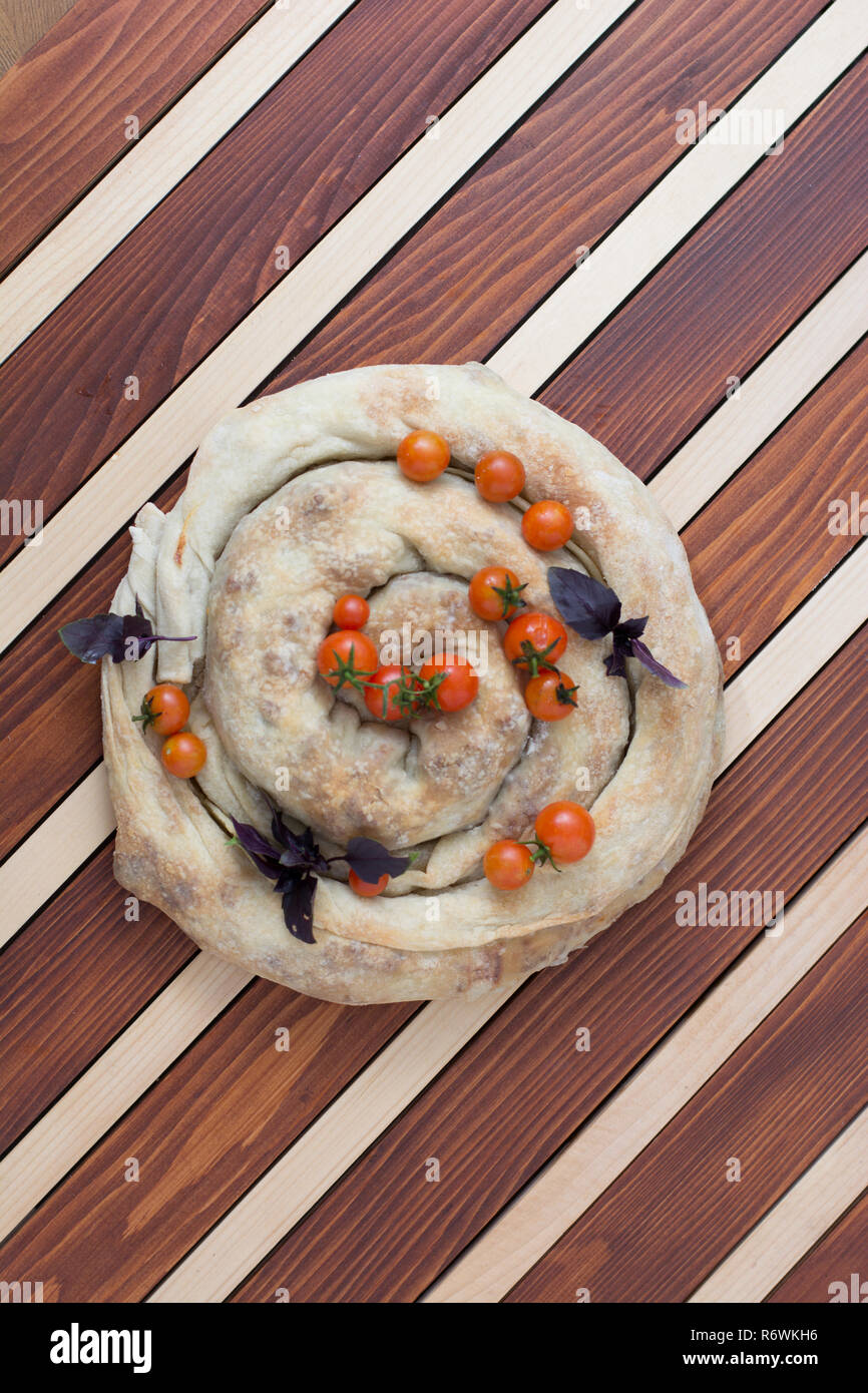 spiral filo pie burek with cherry tomatoes Stock Photo - Alamy